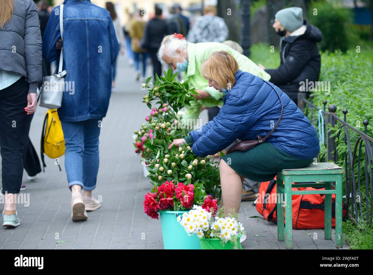 Old women flower sellers sell flowers on the street of the city, people ...