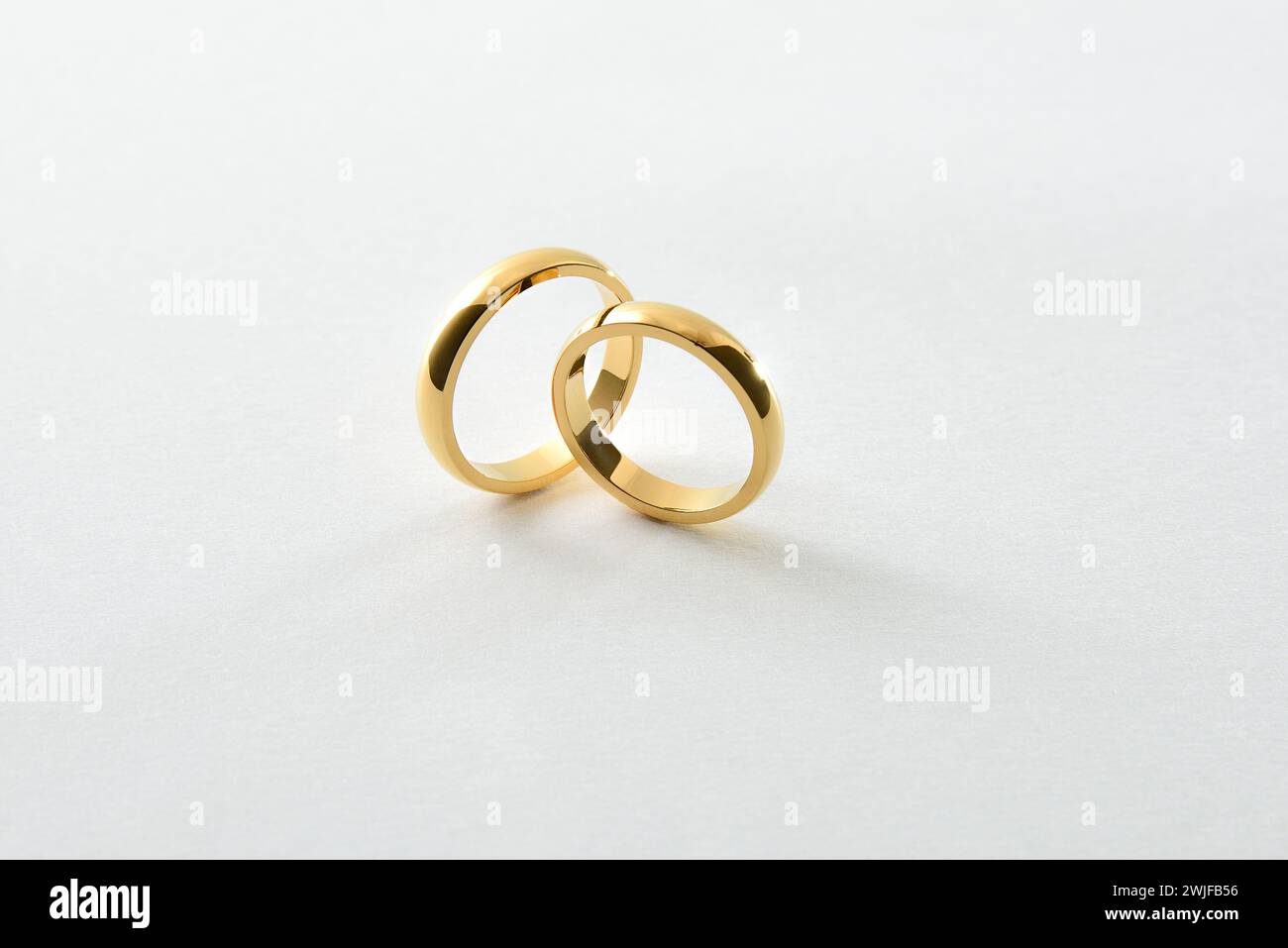 Detail of engagement gold rings standing perpendicular to each other ...
