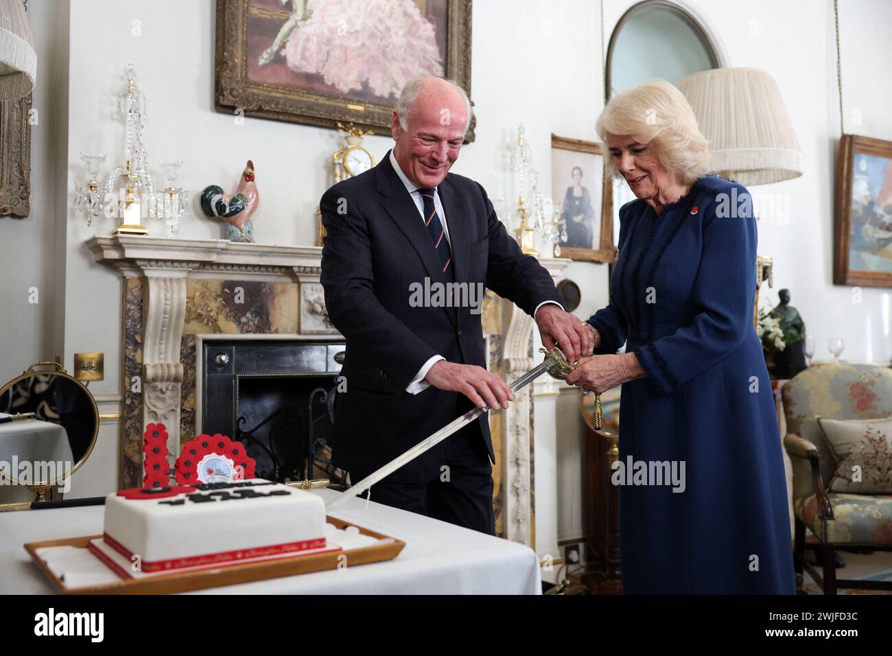 President of The Poppy Factory Surgeon Rear Admiral Lionel Jarvis helps ...