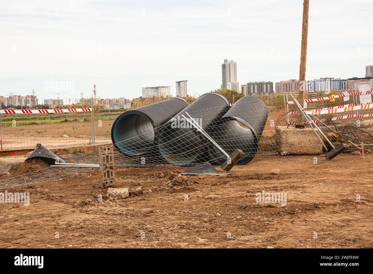 Large metal pipe resting on dirt surface Stock Photo - Alamy