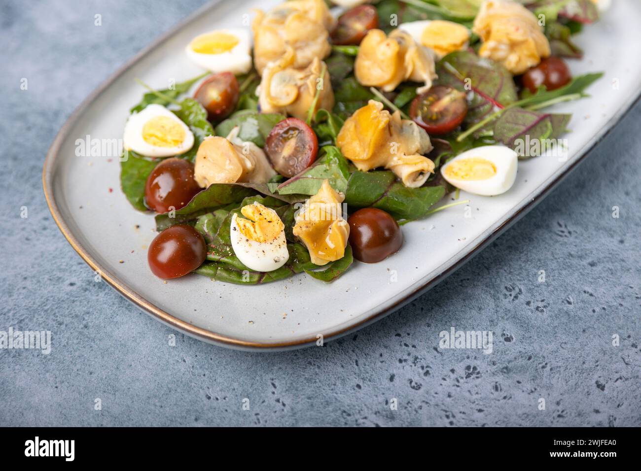 Warm salad with rapan (snails), tomatoes, cucumbers, leafy vegetables ...