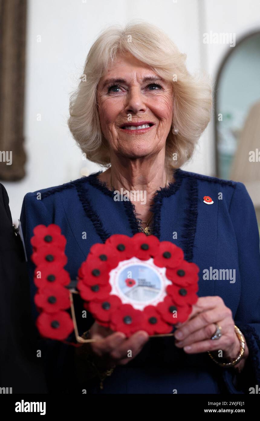 Queen Camilla poses with a gift during a celebration at Clarence House ...