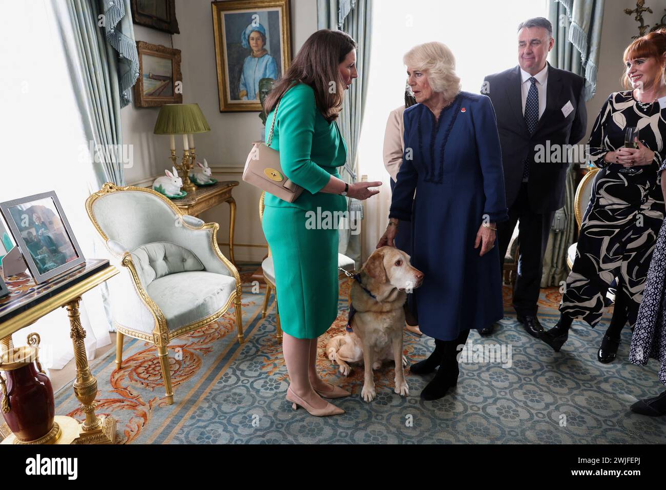 Britian's Queen Camilla pets a dog as she attends a reception at ...
