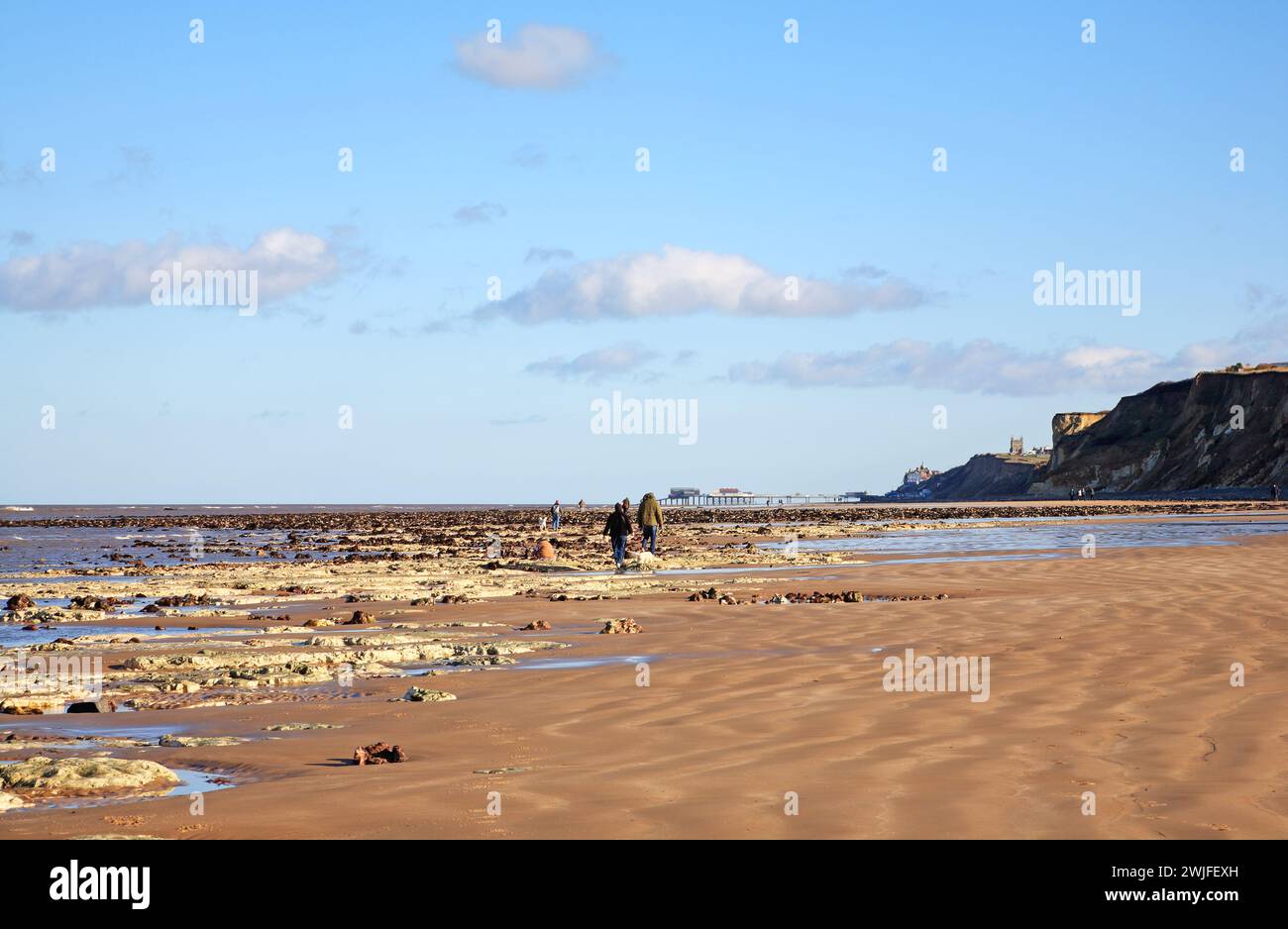 A view eastwards along the shoreline with people, sands, and chalk ...