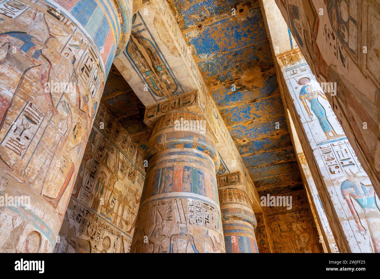 Colorful hieroglyphs carved on columns, interior of Medinet Habu temple ...