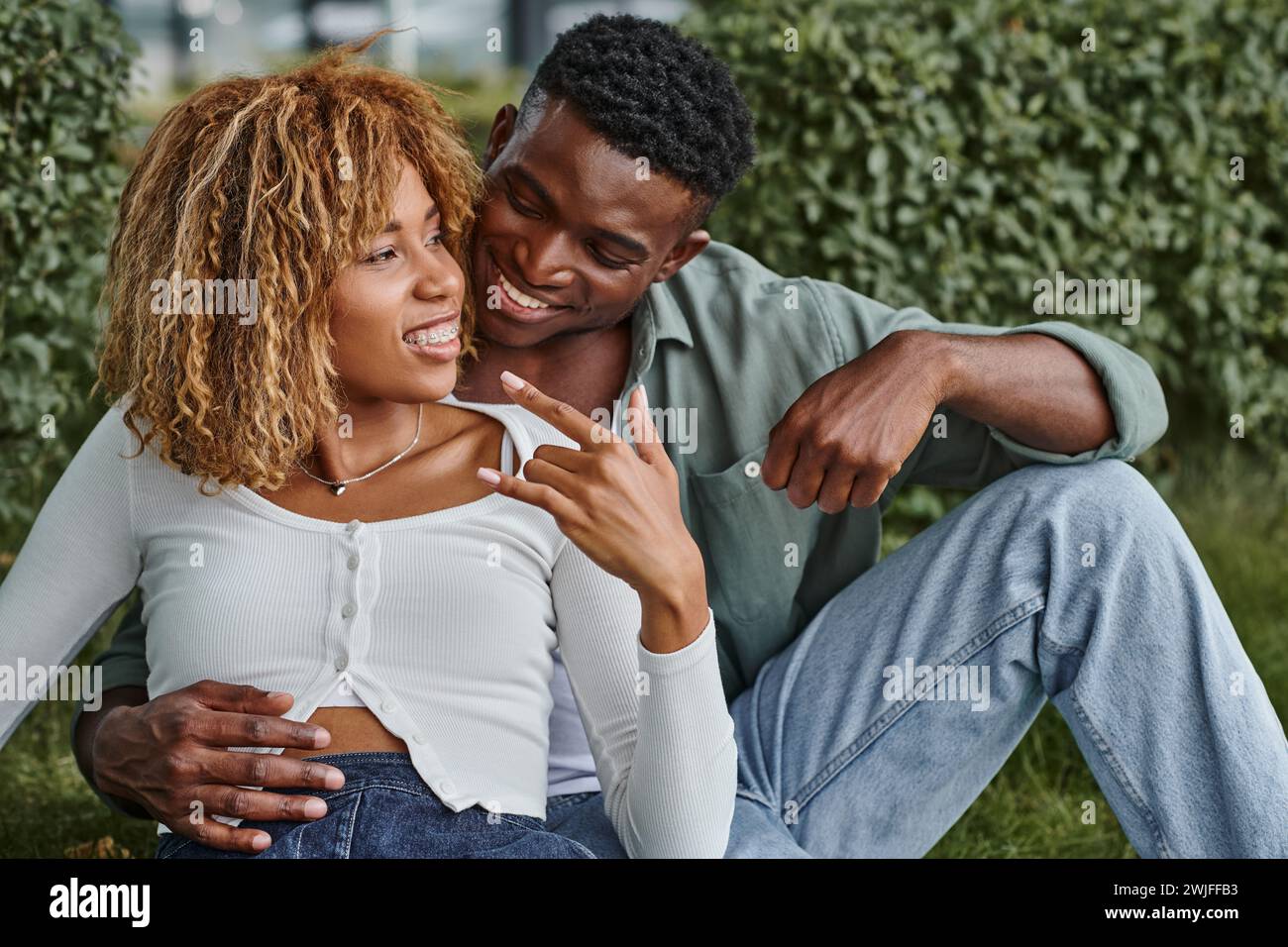 cheerful african american woman in braces using sign language for ...
