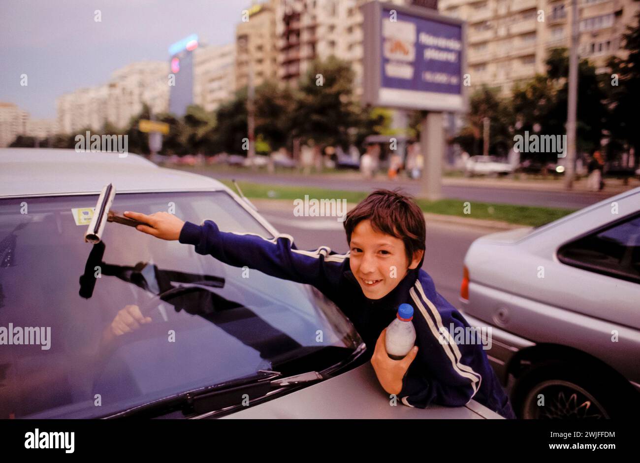 Romania, Bucharest. homeless boys wash cars at the traffic light Stock ...