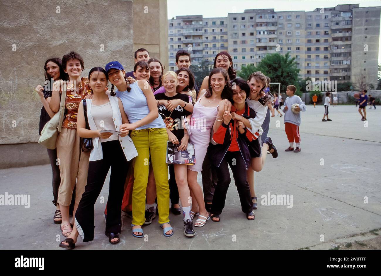 Romania, Bucharest. Girls pose in front of an apartment building after ...