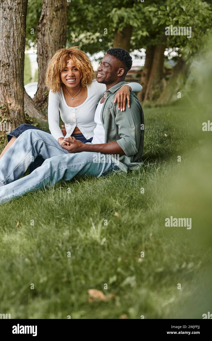 happy african american couple in casual wear hugging while sitting ...