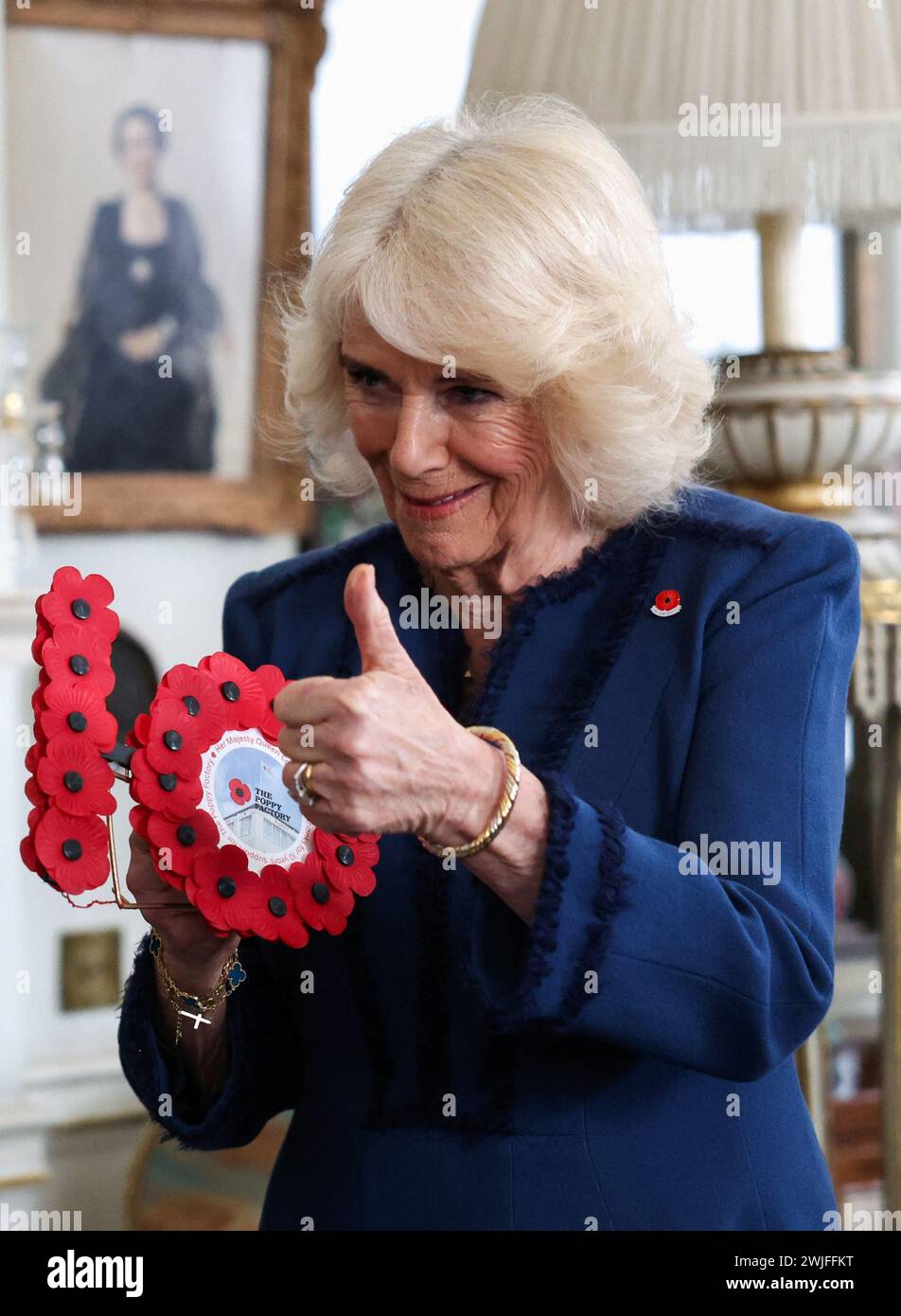 Queen Camilla poses with a gift during a celebration at Clarence House ...