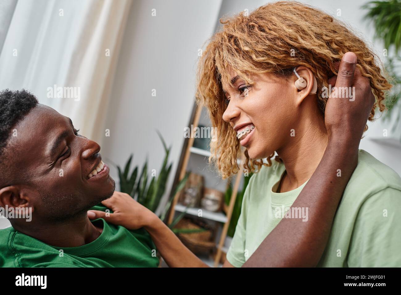 portrait of happy deaf african american woman in hearing aid device ...