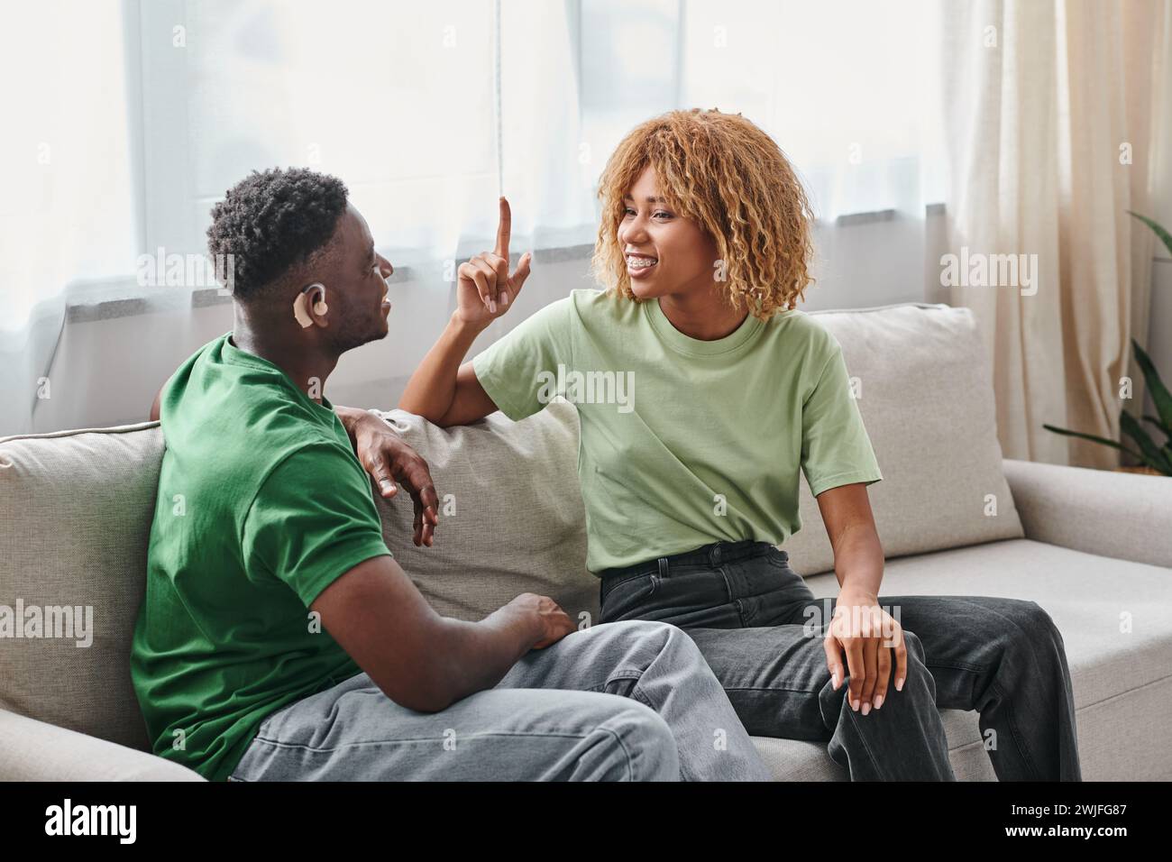 African American couple communicating with sign language on couch ...