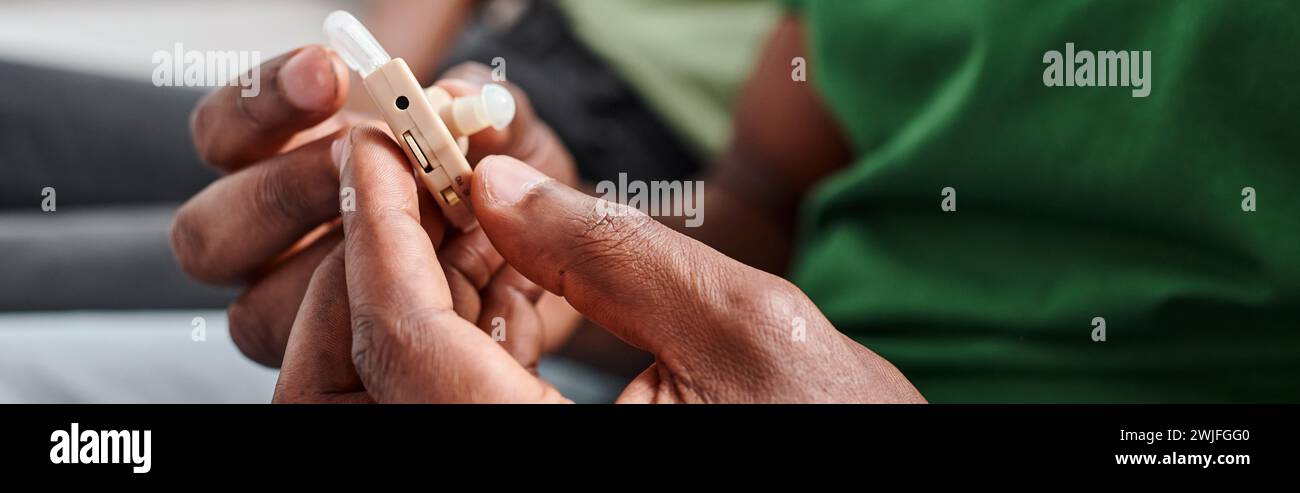 hearing aid in hands on black man, african american person holding ...