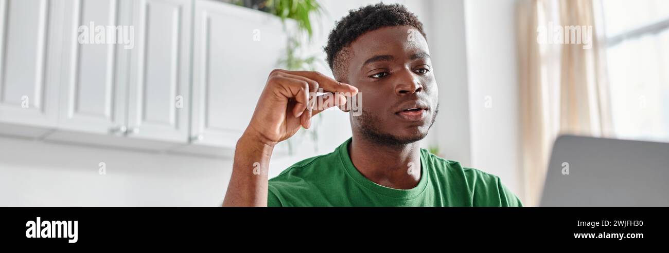 focused african american man using sign language during video call on ...