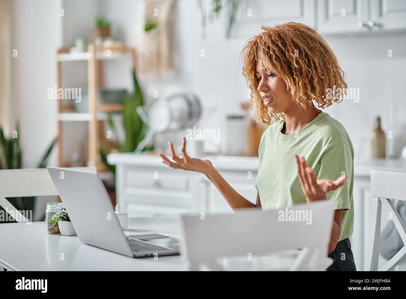 curly african american woman in braces using sign language during video ...