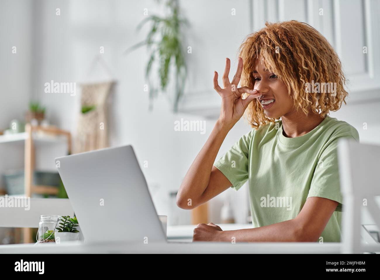joyful african american woman in braces using sign language during ...