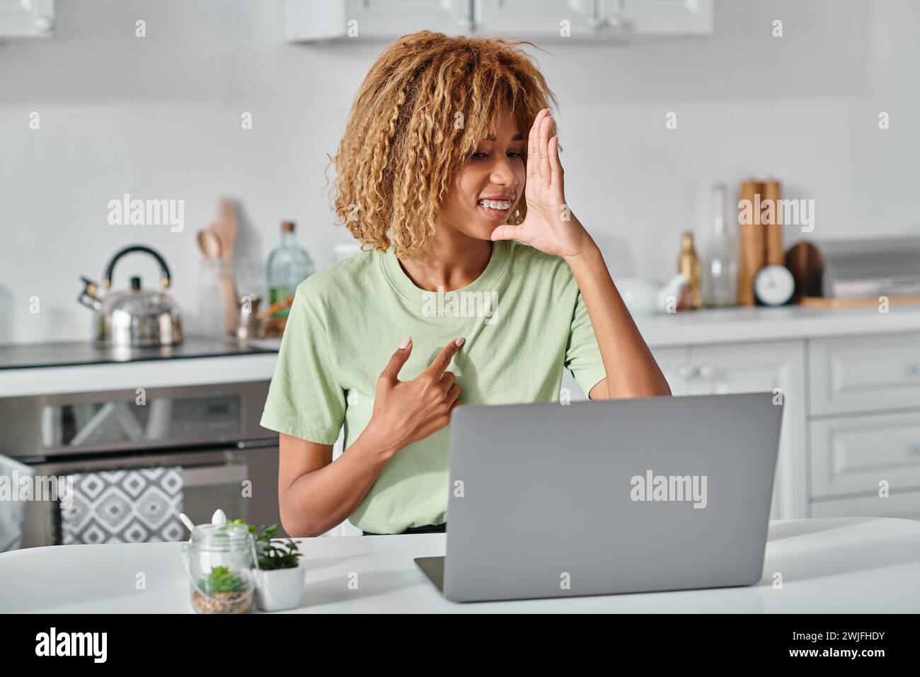 positive african american woman using sign language during video call ...