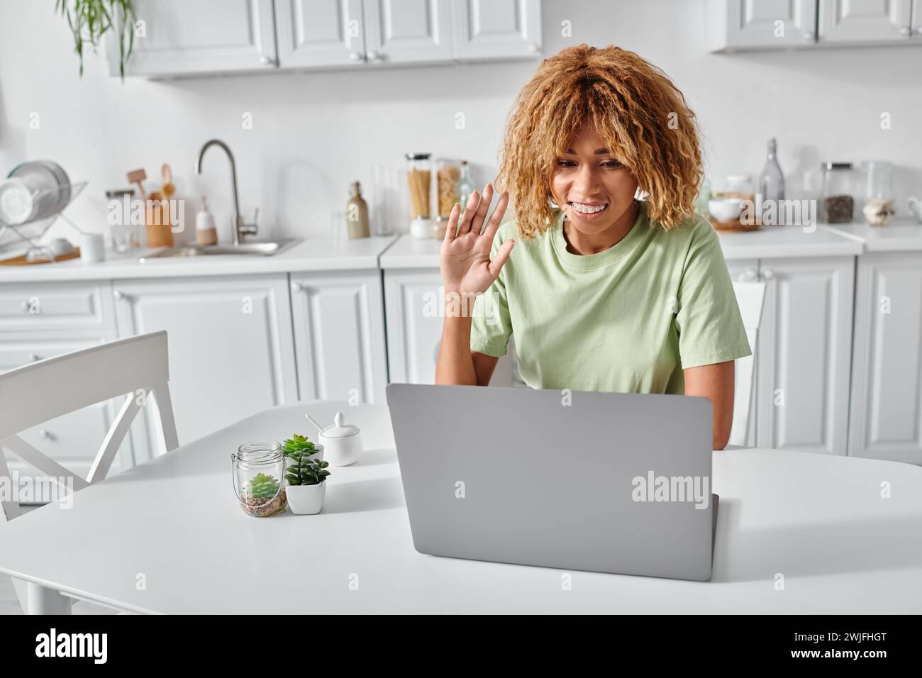 smiling african american woman using sign language during a video call ...