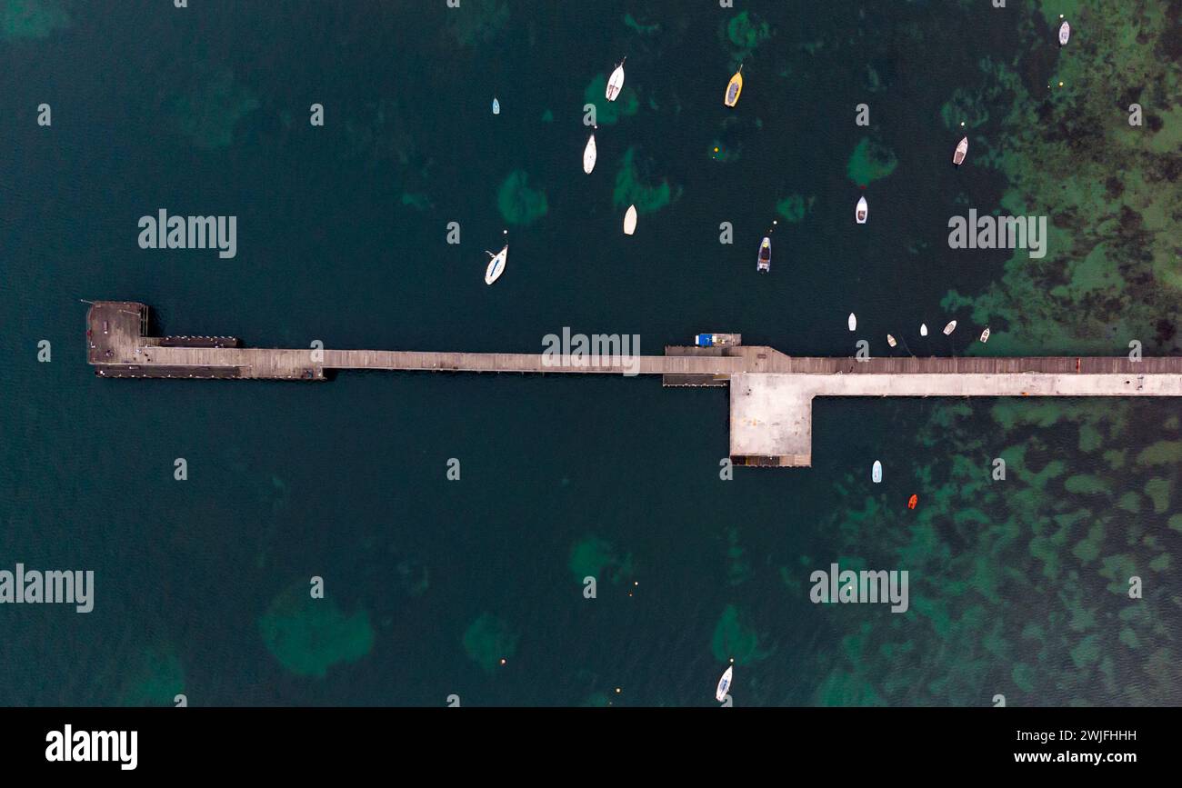 Aerial view of boats sailing beneath a bridge on a serene waterway ...