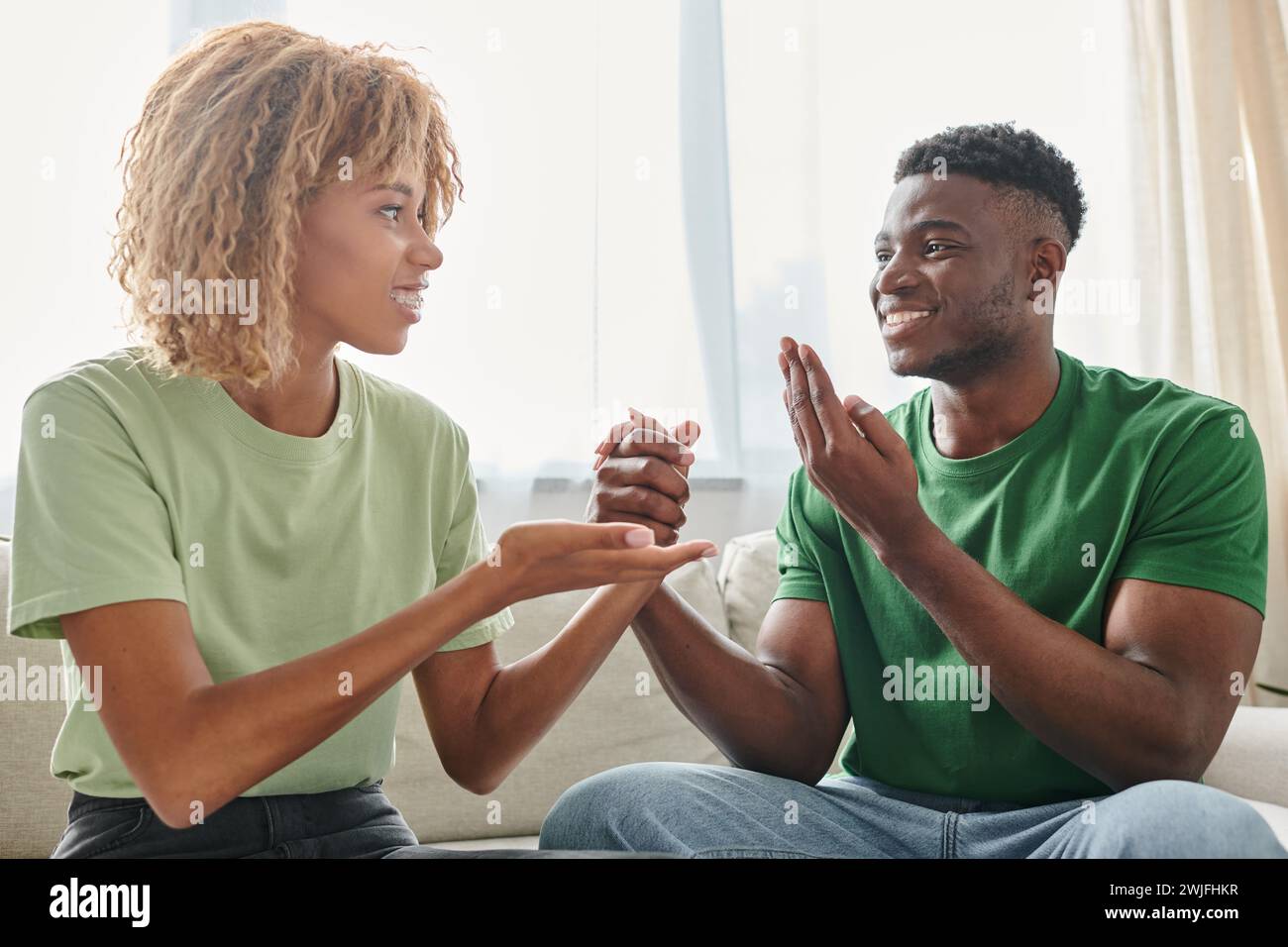happy African American couple communicating with sign language while ...