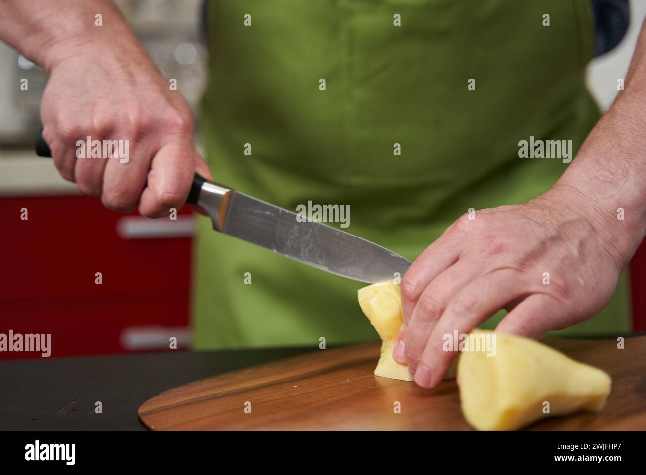 Man chef chopping ginger finely on a wooden board with a very sharp ...