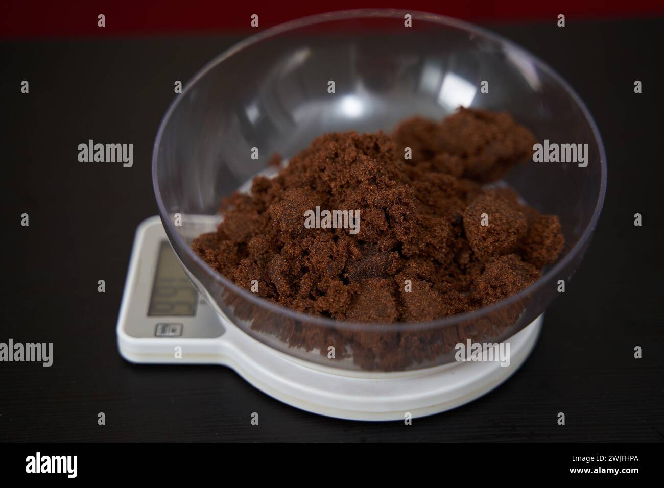 Weighing muscovado sugar on a kitchen scale Stock Photo - Alamy