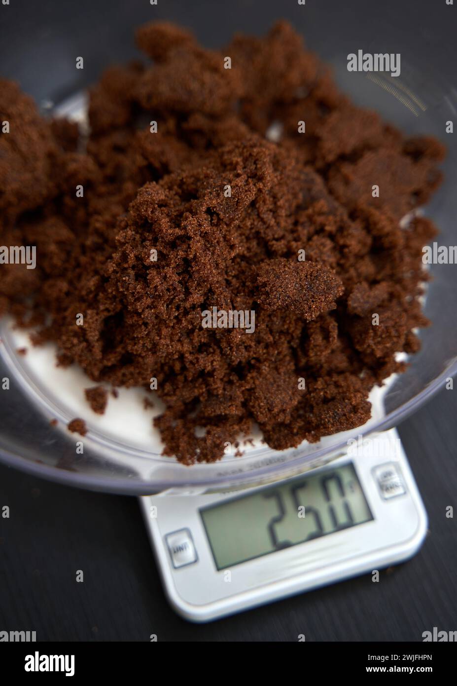 Weighing muscovado sugar on a kitchen scale Stock Photo - Alamy
