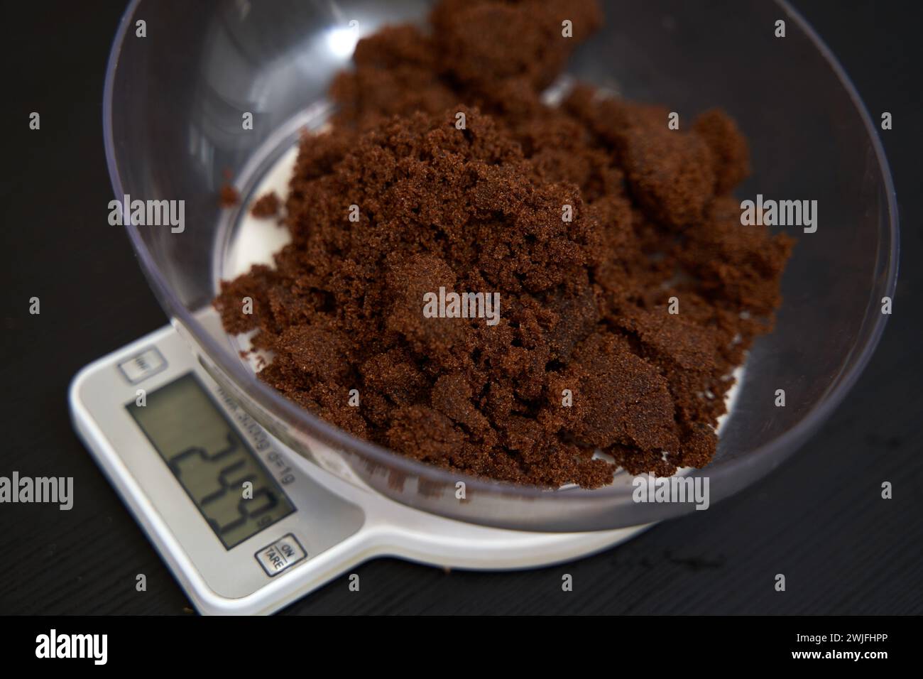 Weighing muscovado sugar on a kitchen scale Stock Photo - Alamy