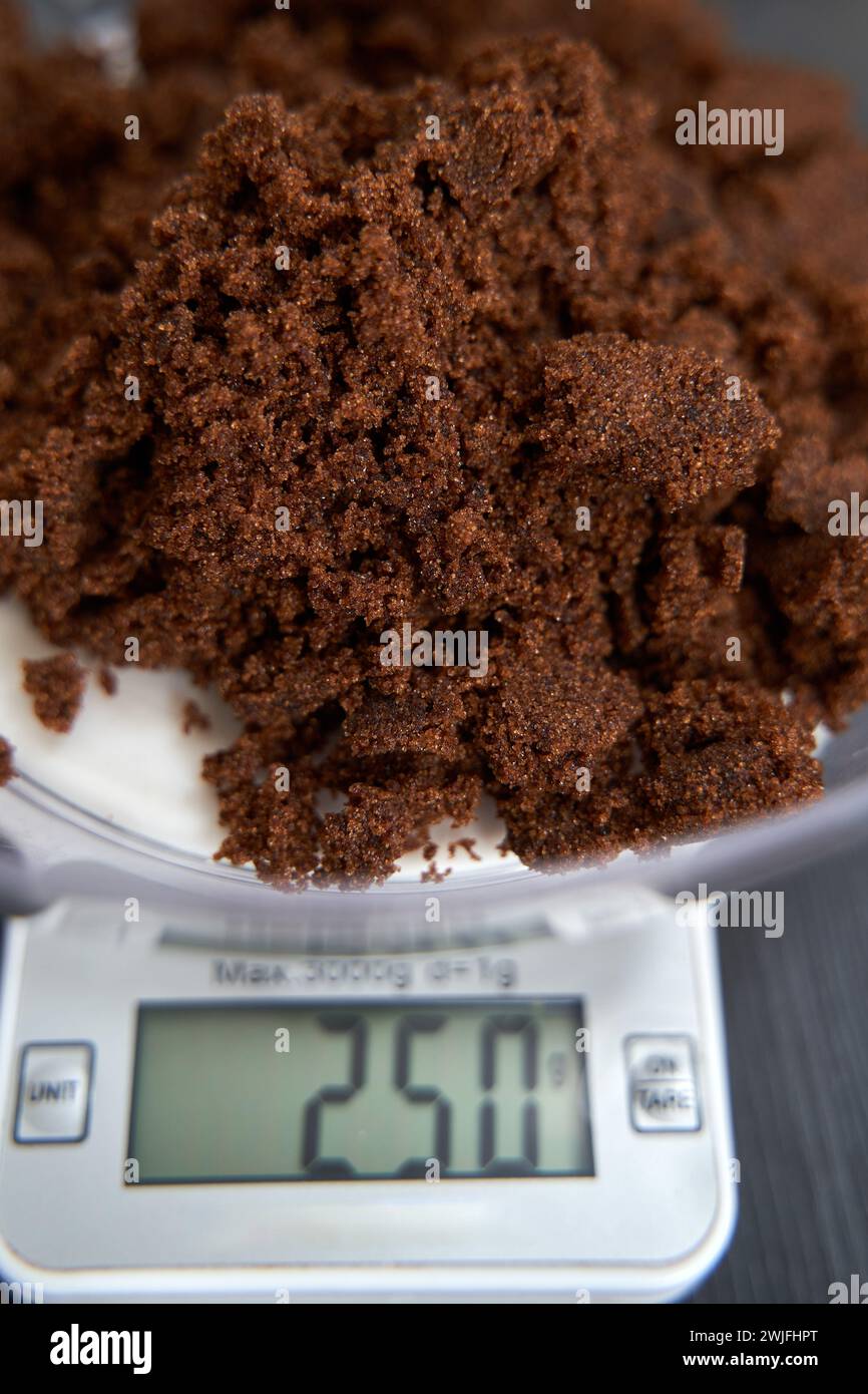 Weighing muscovado sugar on a kitchen scale Stock Photo - Alamy