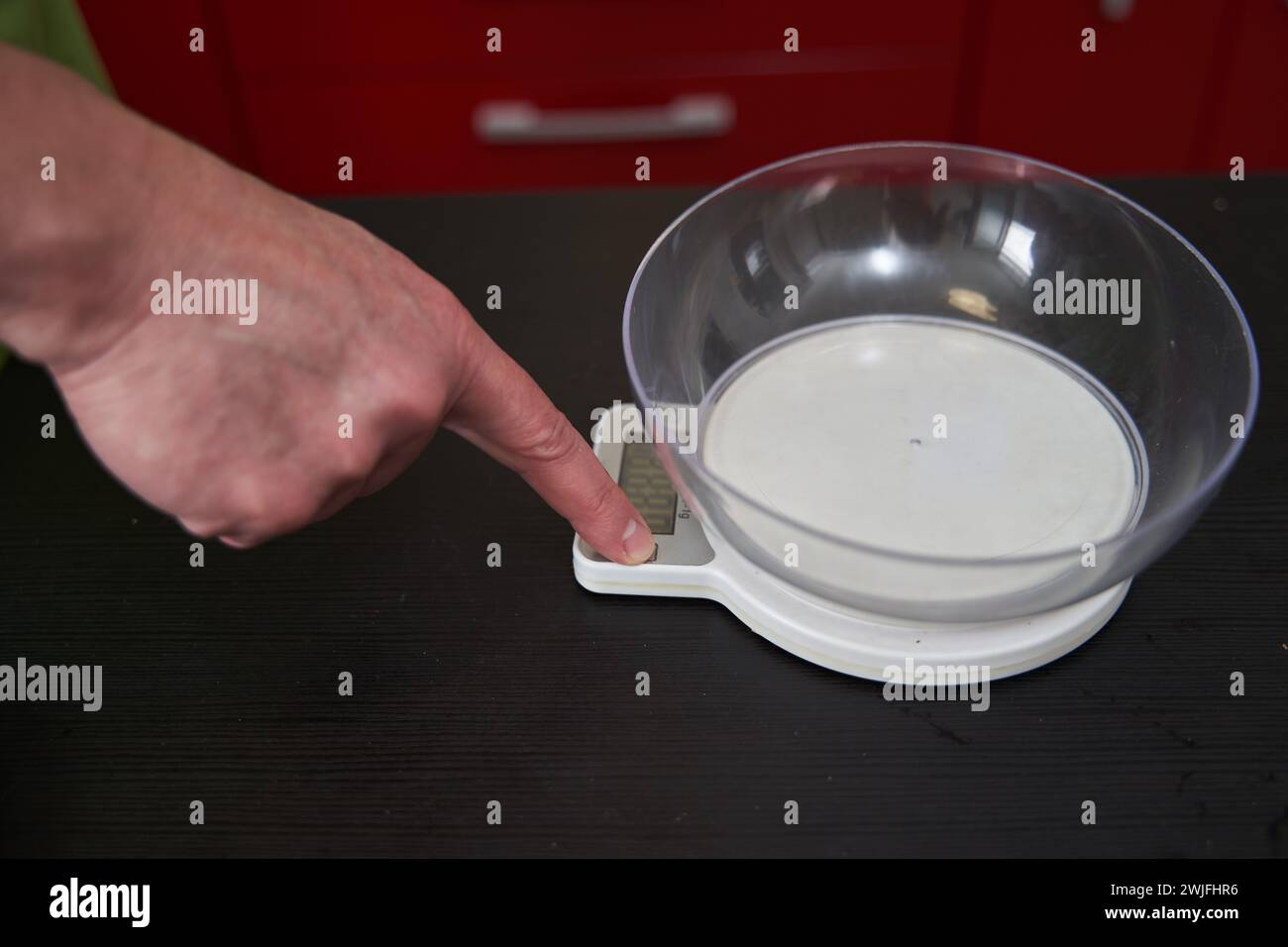 Chef's hand setting up the kitchen scale for use Stock Photo - Alamy