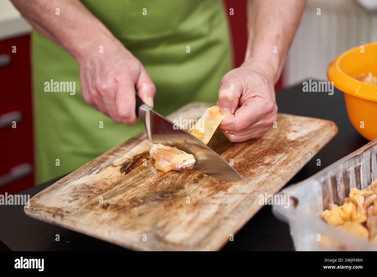 Cook removing chicken skin from wings for a recipe without cholesterol ...