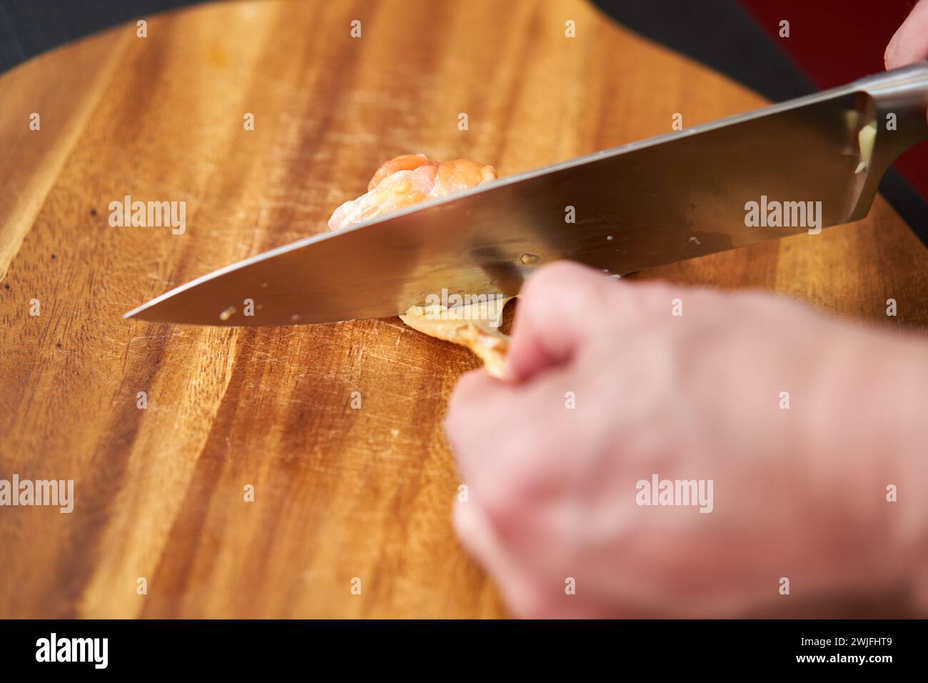 Cook removing chicken skin from wings for a recipe without cholesterol ...