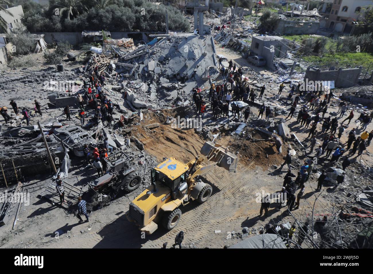 Palestinians inspect the wreckage of the destroyed buildings and the ...