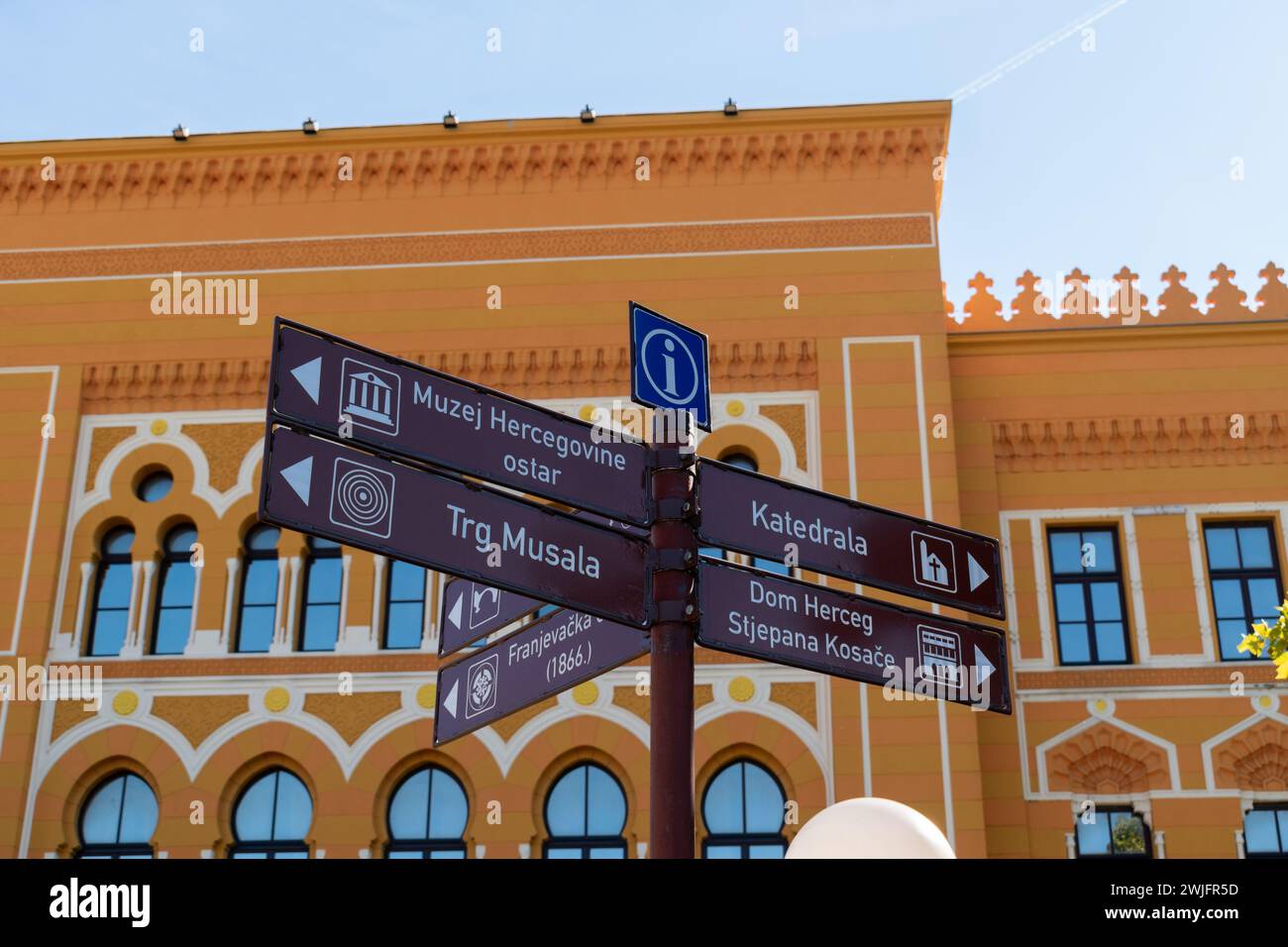 Tourist info sign with directions in front of old gymnasium in Mostar ...