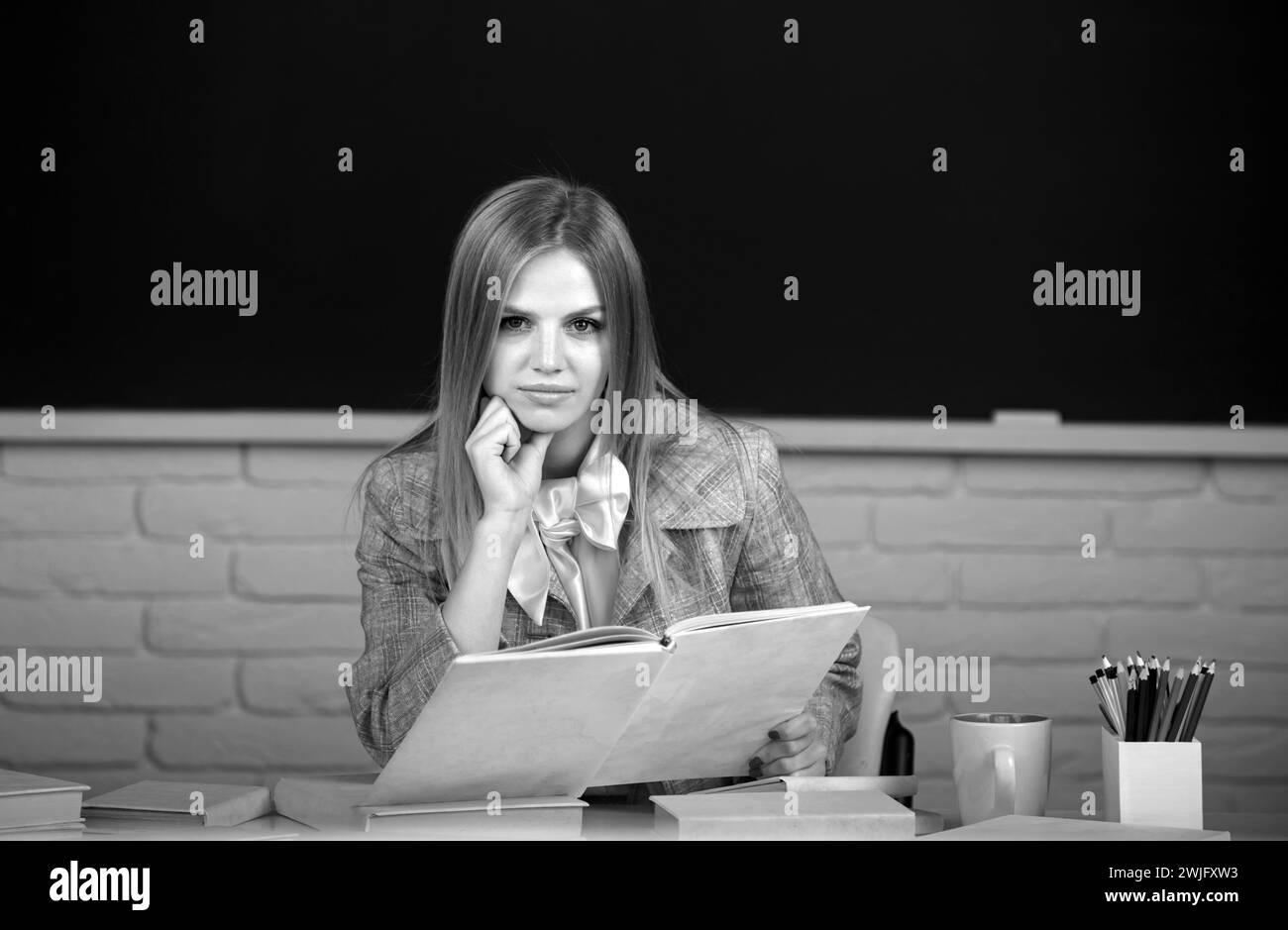 Female college student reading book in classroom, preparing for exam ...
