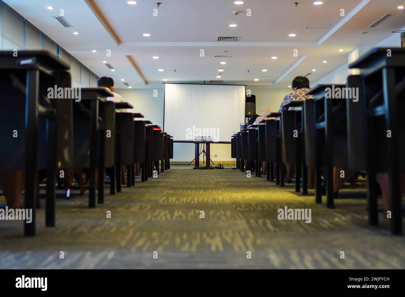 Seminar room with projector screen and rows of tables Stock Photo - Alamy