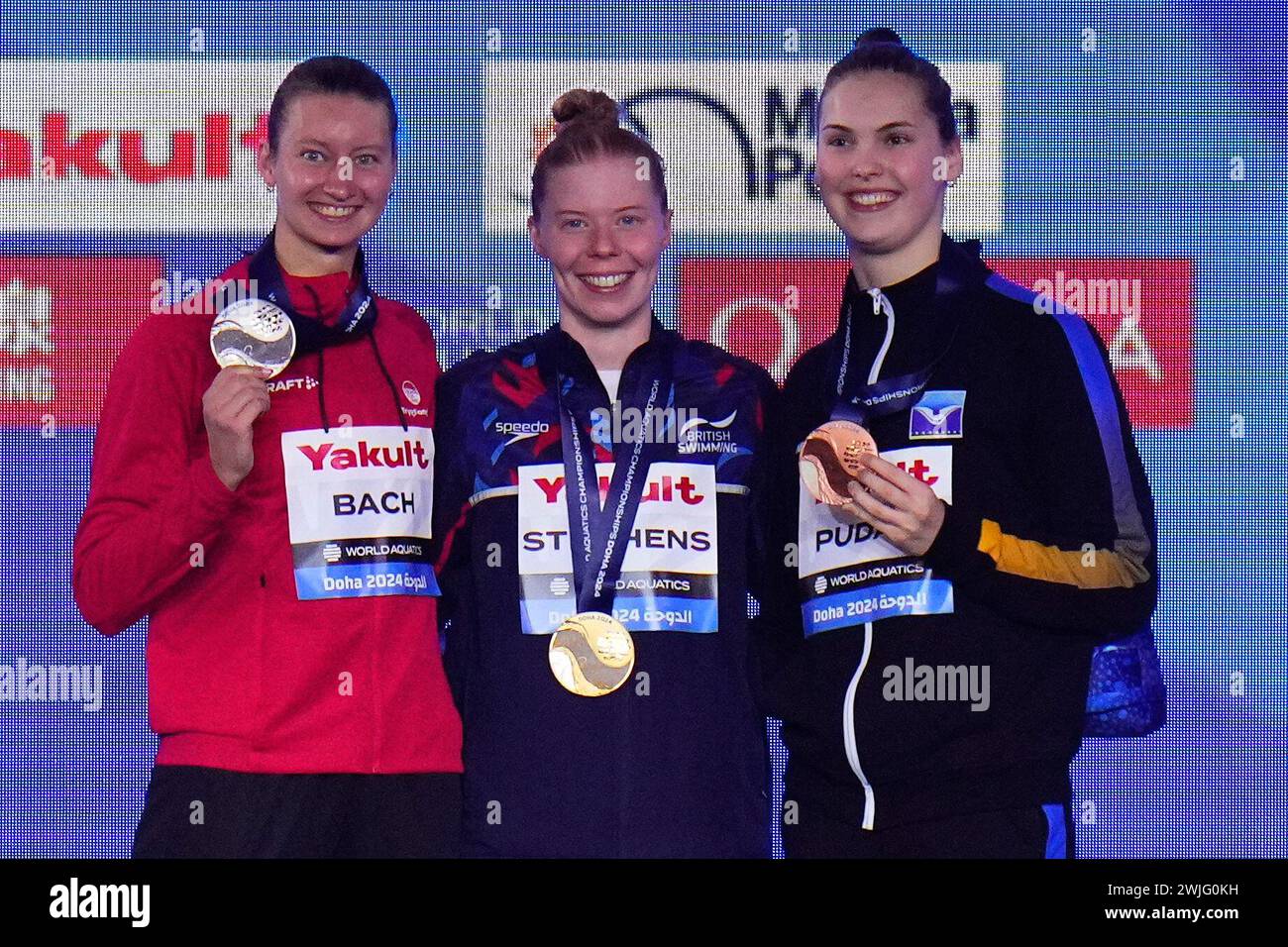 Laura Stephens of Britain, center, holds up her gold medal next to ...