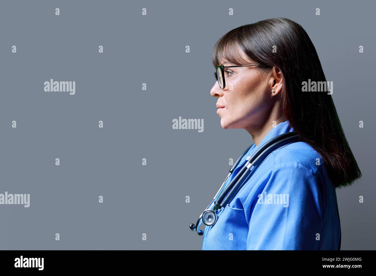 Portrait of middle-aged confident female nurse looking in profile on ...
