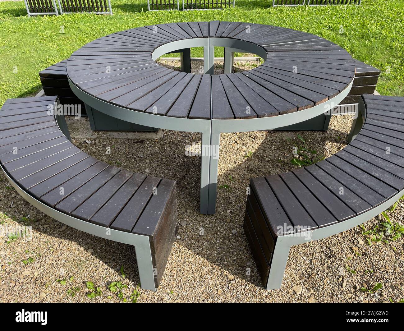 A wooden picnic table with benches in a park. The table is set for a ...