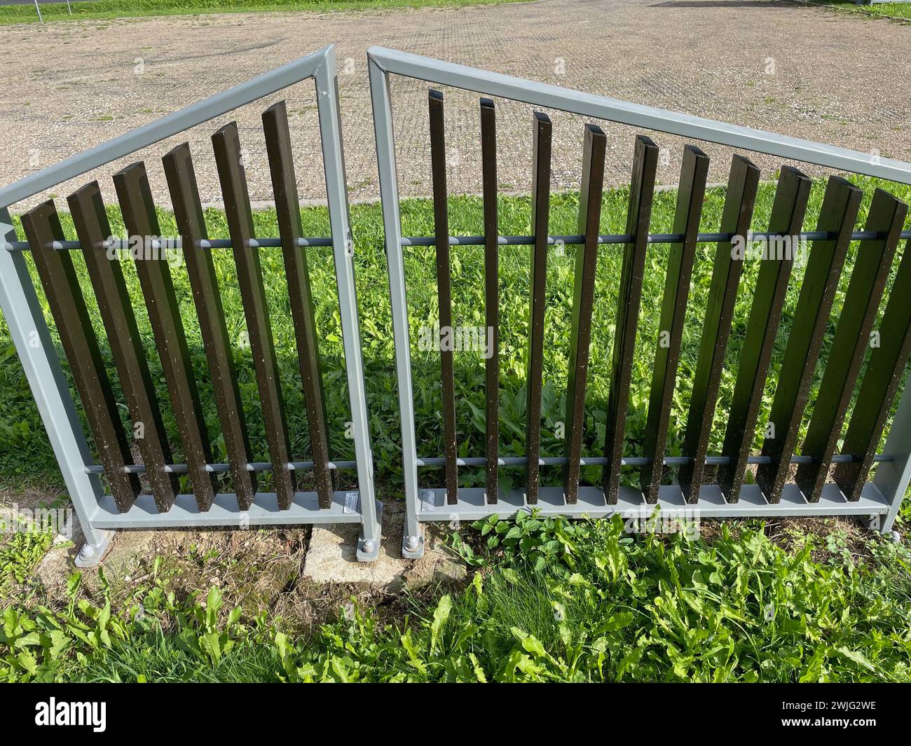 Steel fence with vertical rails painted brown Stock Photo - Alamy