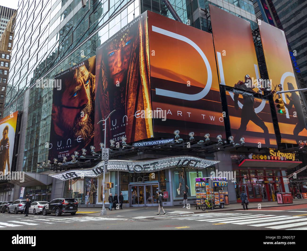Hordes of people cross West 42nd Street under advertising for the ...