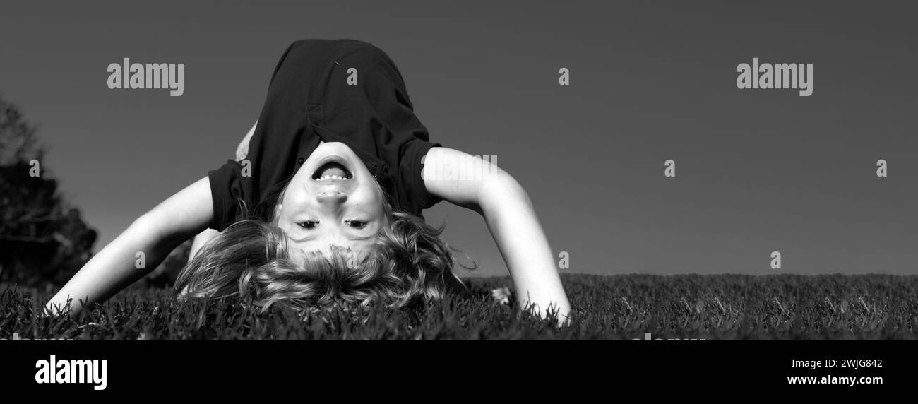 Banner with spring kids portrait. Happy child playing upside down on ...