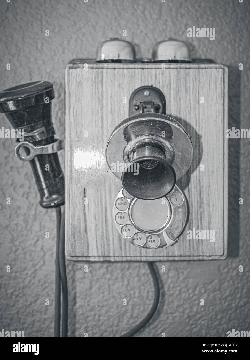 Black and white photograph of an antique wooden telephone hanging on a ...