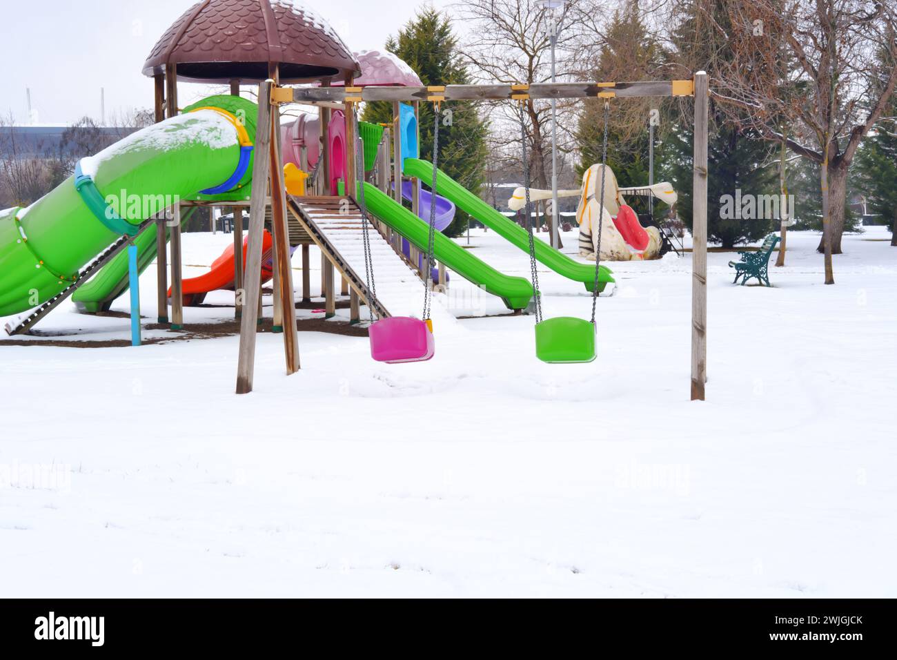 Colorful park with plastic swings and slides under snow in winter Stock ...