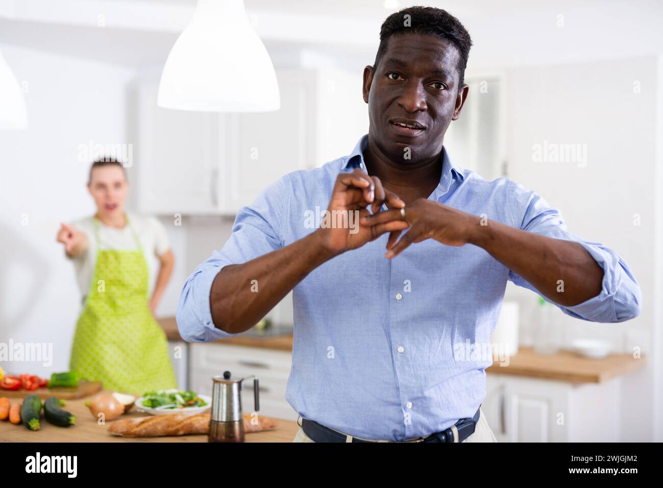 Frustrated man removing wedding ring from finger on background of angry ...