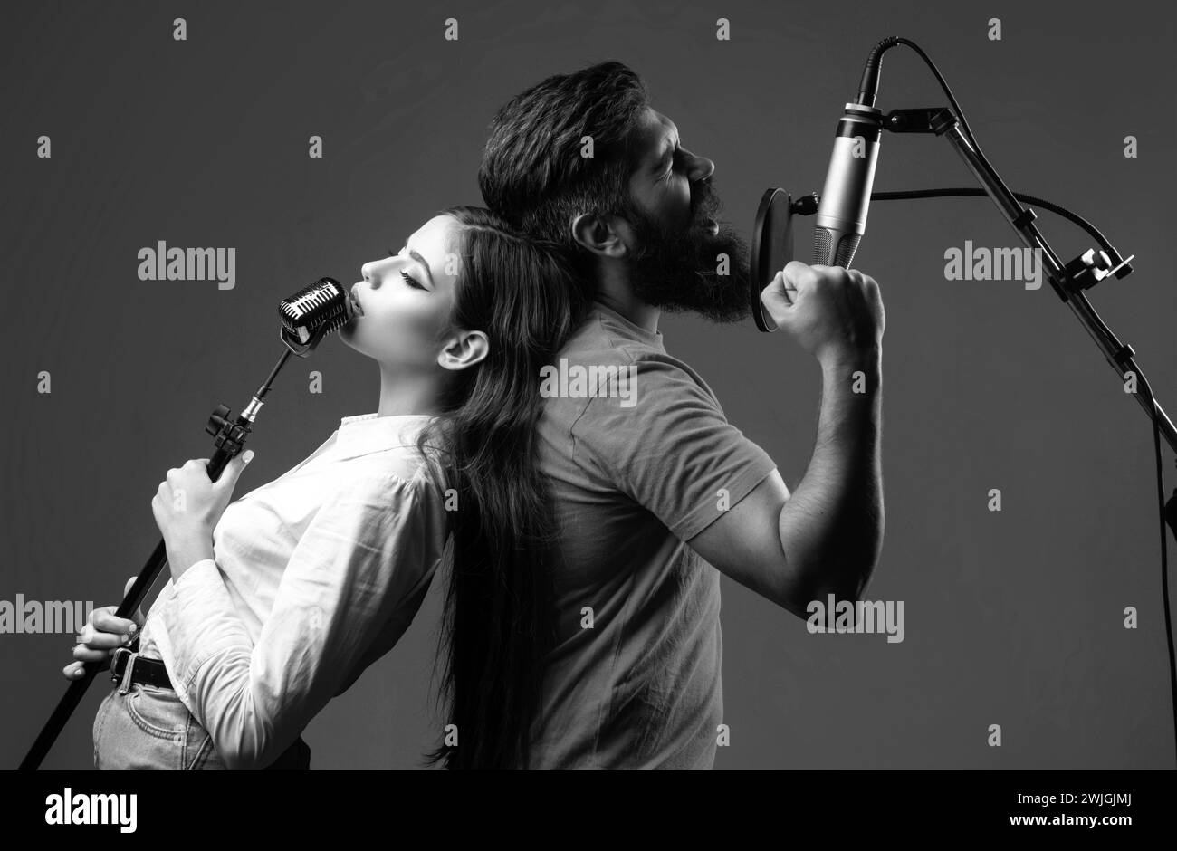 Boy and girl with excited faces enjoy music. Couple in recording studio ...