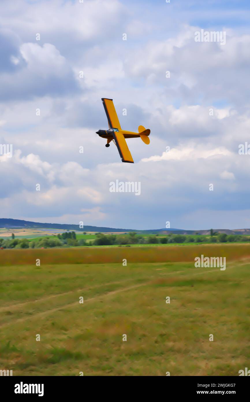 Yellow single engine airplane maneuvering close to the ground with ...