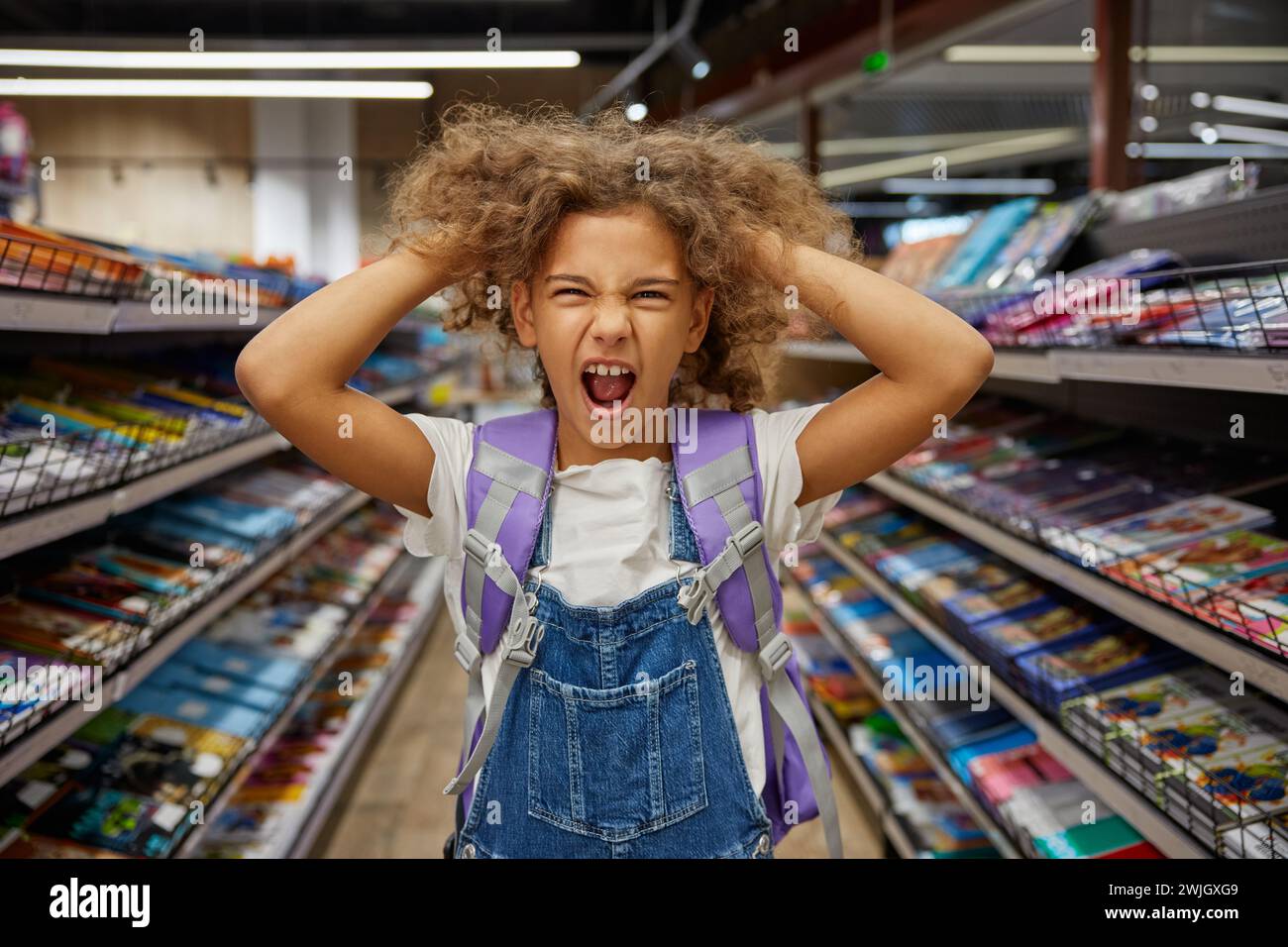 Stressed girl child feeling crazy during shopping at stationery shop ...