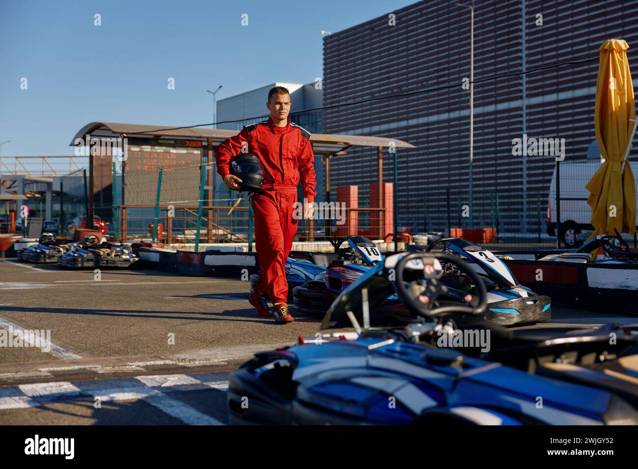 Go-kart driver walking to car before race at starting line Stock Photo ...