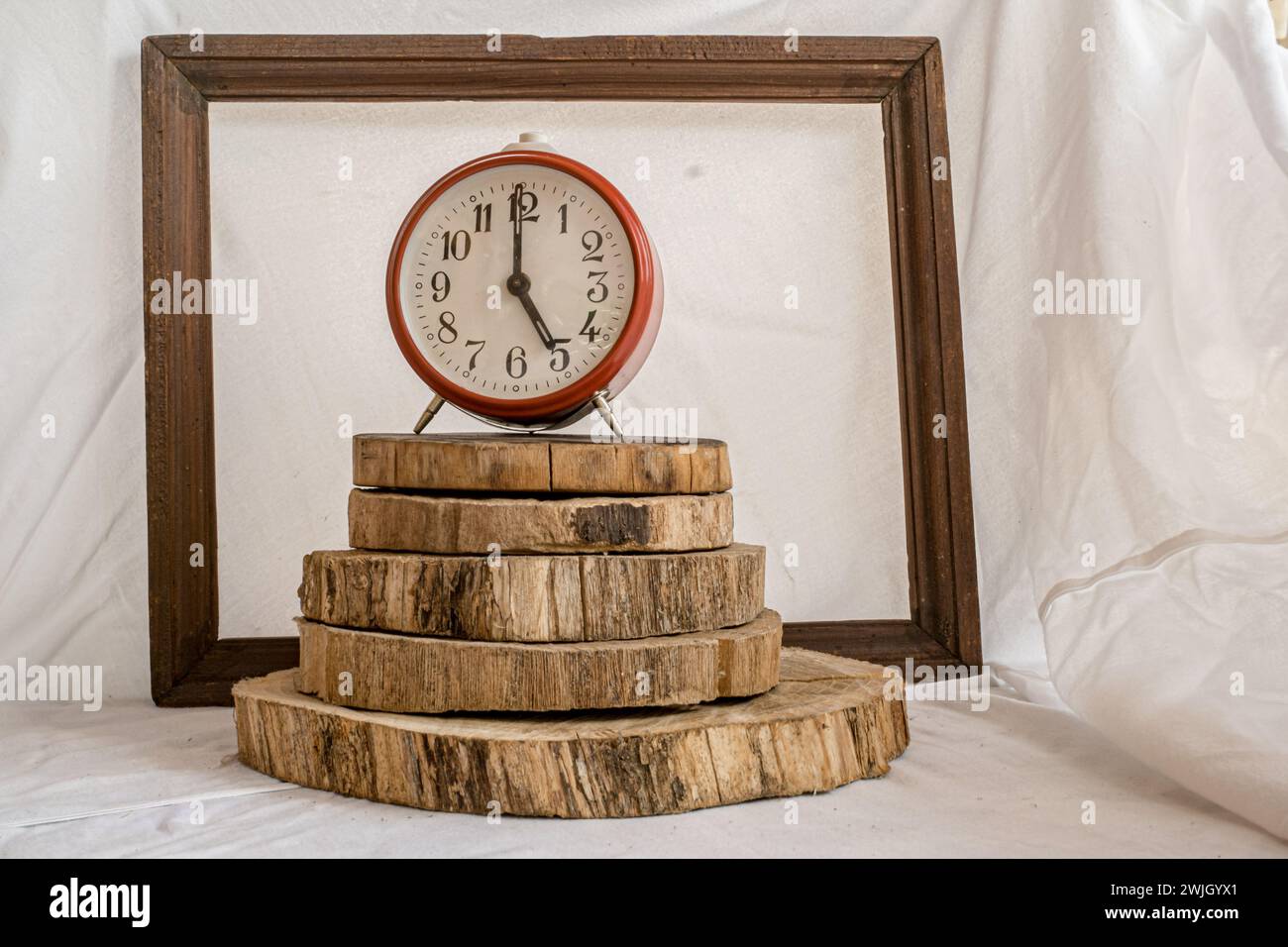 Alarm clock on tree trunk rings with wooden frame on dirty white cloth ...